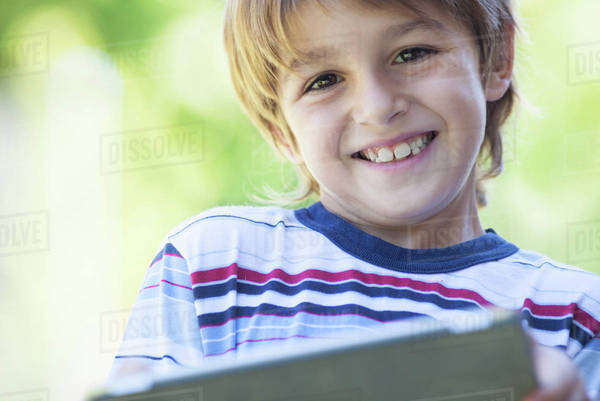 Boy holding digital tablet - Royalty-free Stock Photo | Dissolve