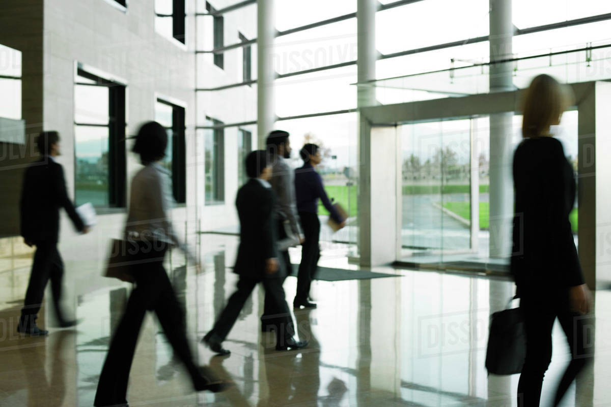 Executives walking toward lobby exit - Royalty-free Stock Photo | Dissolve