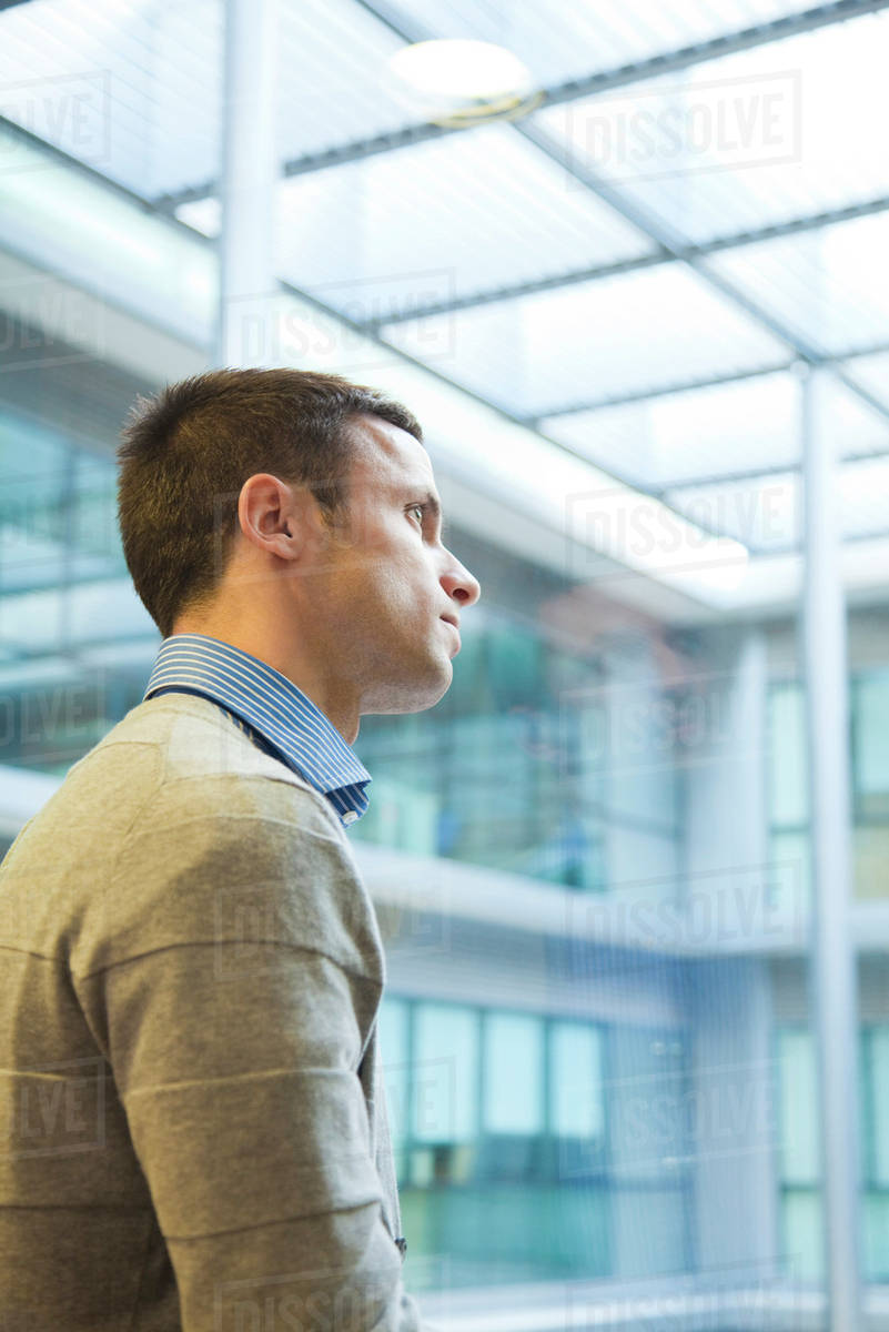 Man looking through window, portrait - Stock Photo - Dissolve