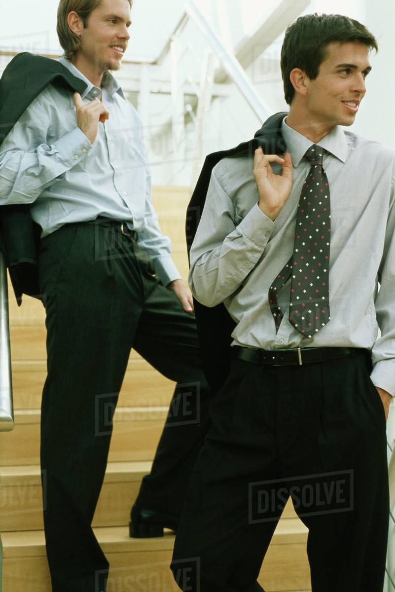 Businessmen standing on steps, suit jackets over shoulder - Royalty ...
