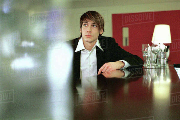 Well dressed young man leaning on bar, looking away - Royalty-free ...