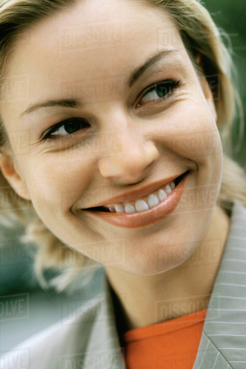 Woman smiling glancing sideways, portrait - Stock Photo - Dissolve