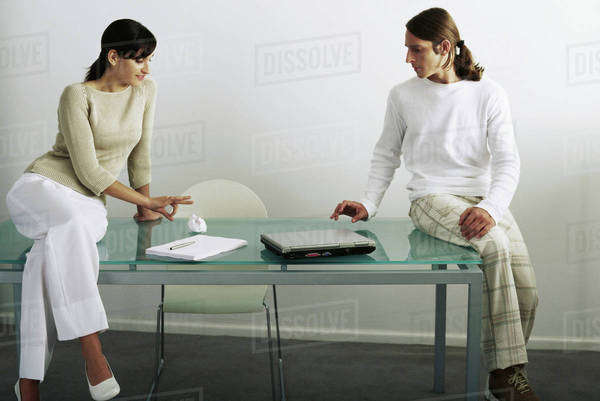 Colleagues flicking paper ball back and forth across table - Royalty ...