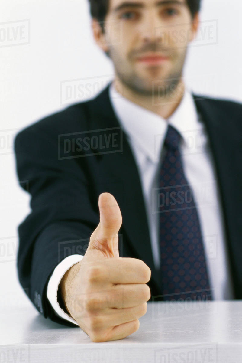 Businessman giving thumbs up - Stock Photo - Dissolve