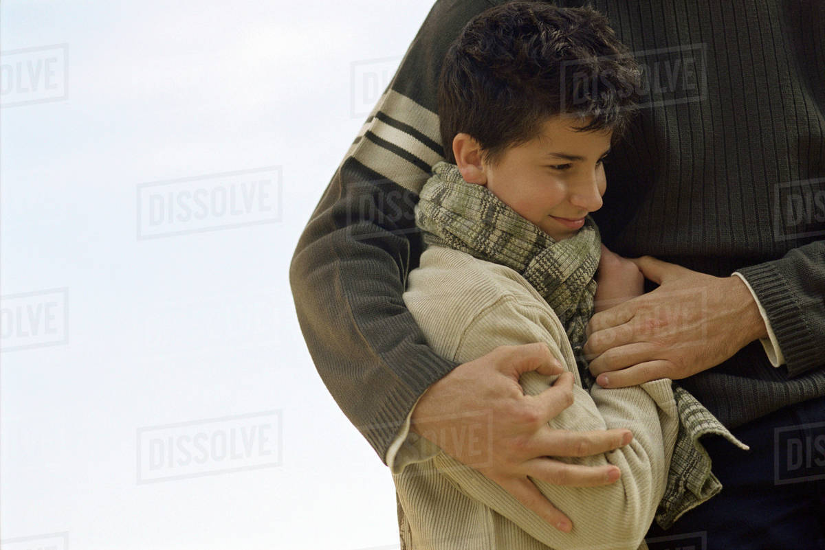 Boy being embraced by father, cropped - Royalty-free Stock Photo | Dissolve