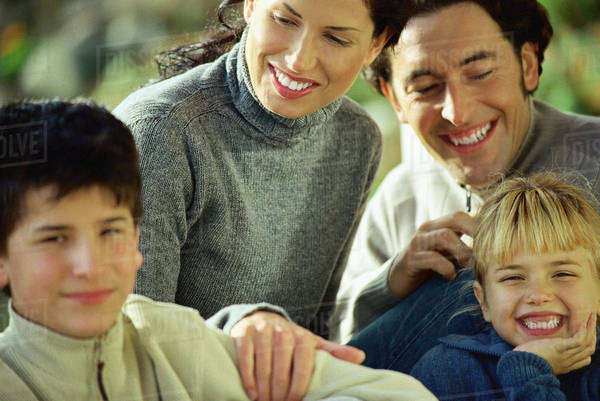 Parents sitting outdoors with their two children - Royalty-free Stock ...