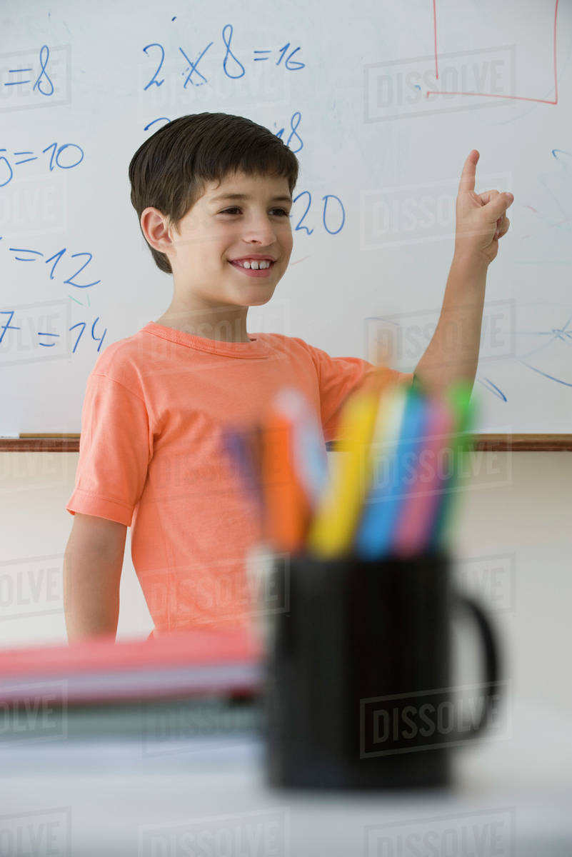 Elementary school student standing in front of class, pointing at ...