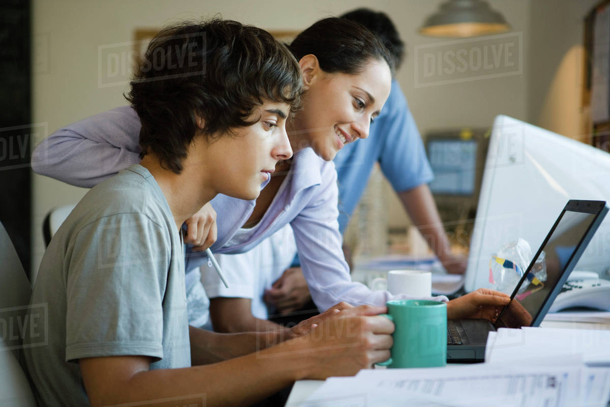 Male college student using laptop computer, female classmate looking ...