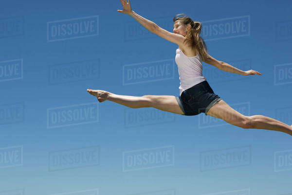 Young woman leaping, midair - Royalty-free Stock Photo | Dissolve
