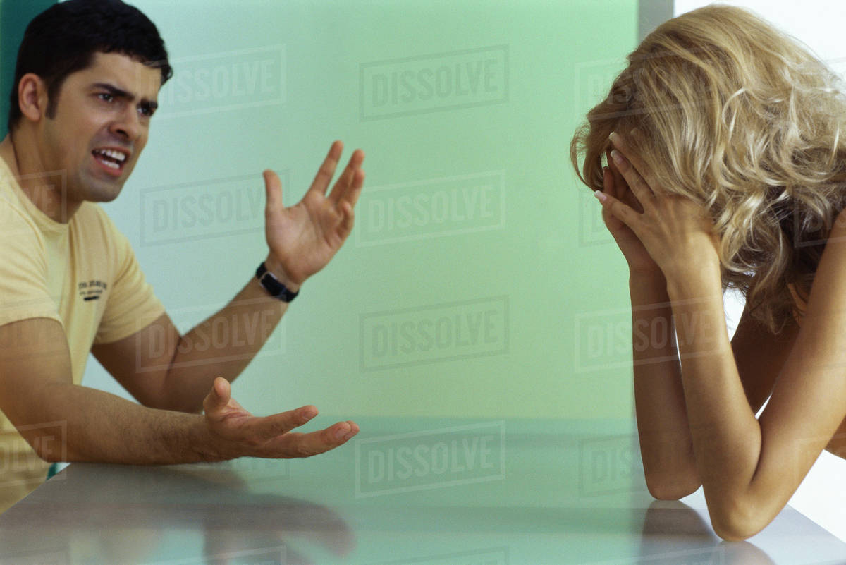 Couple arguing at table, woman holding head - Royalty-free Stock Photo ...