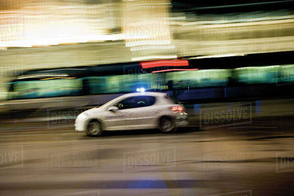 Car speeding down street at night - Royalty-free Stock Photo | Dissolve