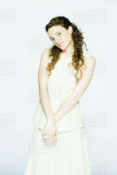 Young woman with hands clasped in front of her, smiling, portrait ...