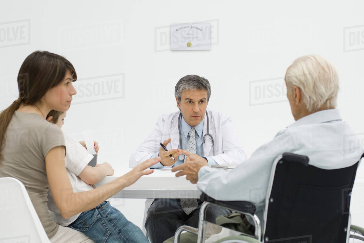 Doctor sitting at desk, having discussion with senior patient and his ...