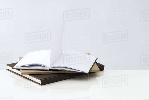 Stack of books, one open book with blank pages inside - Royalty-free ...