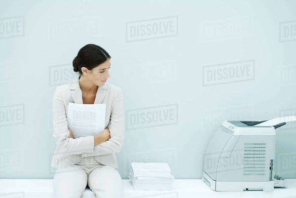 Young woman in suit sitting next to printer - Royalty-free Stock Photo ...