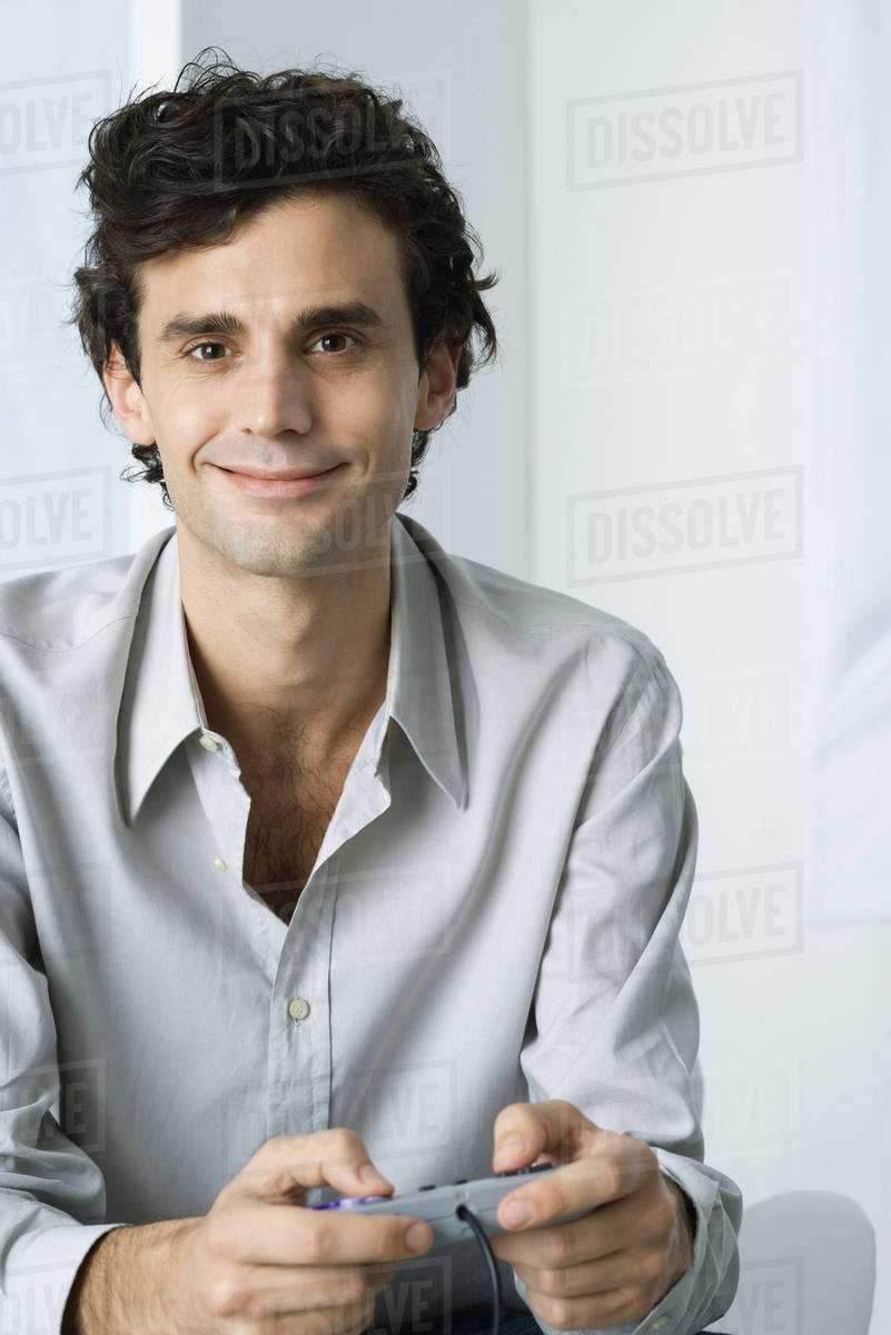 Man holding video game controller, smiling at camera - Royalty-free ...