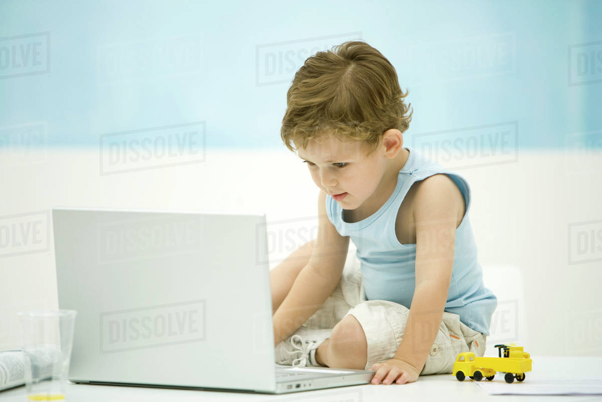 Little boy looking at laptop computer - Royalty-free Stock Photo | Dissolve