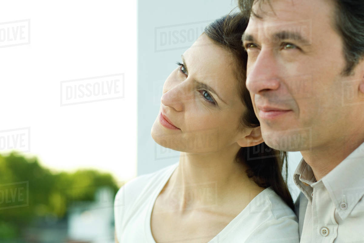 Woman leaning her head against man's cheek, both looking away - Stock ...