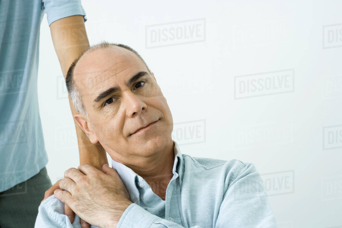 Man with son's hand on his shoulder, smiling at camera, cropped ...