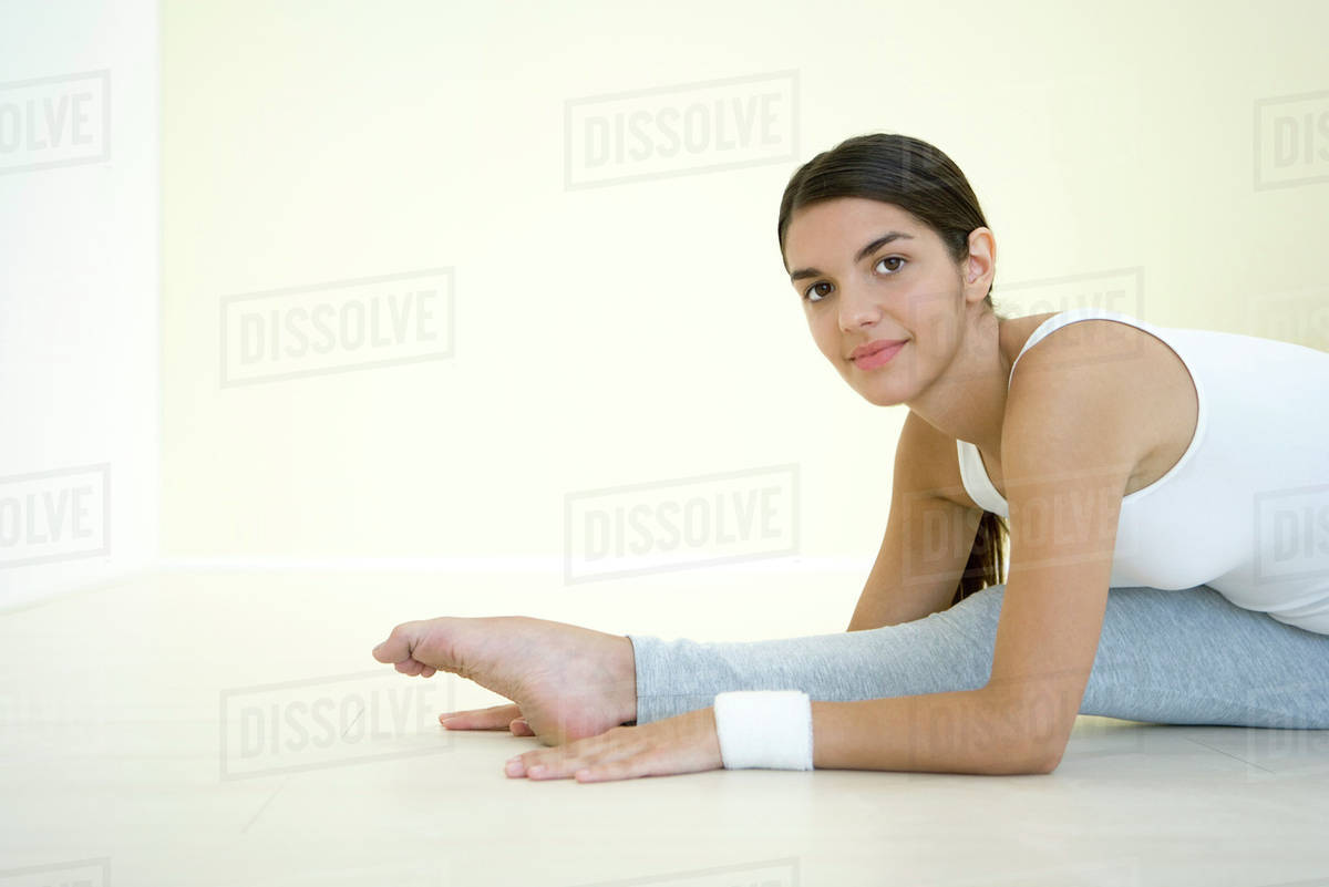 Woman doing split, smiling at camera - Stock Photo - Dissolve