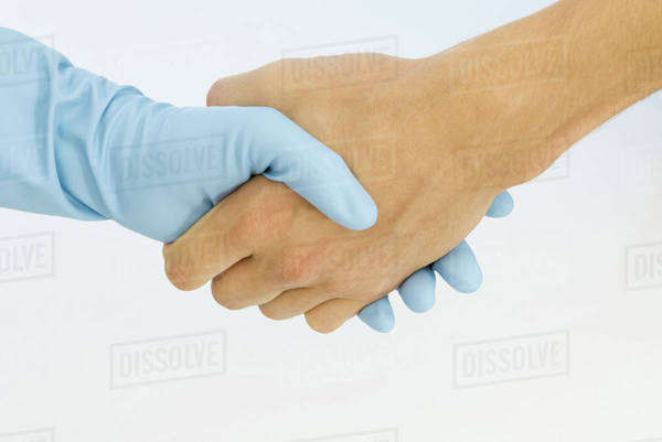 Cropped view of handshake, one hand wearing rubber glove, close-up ...