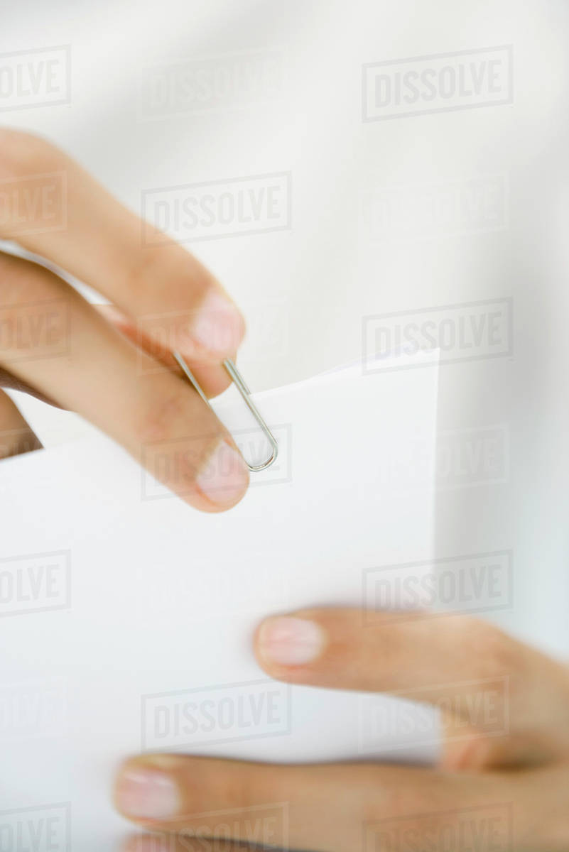 Hands putting paperclip on document, close-up - Royalty-free Stock ...