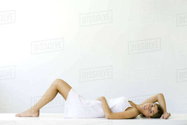 Woman lying on back, smiling at camera - Stock Photo - Dissolve