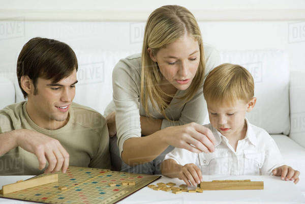 Family playing board game together - Stock Photo - Dissolve