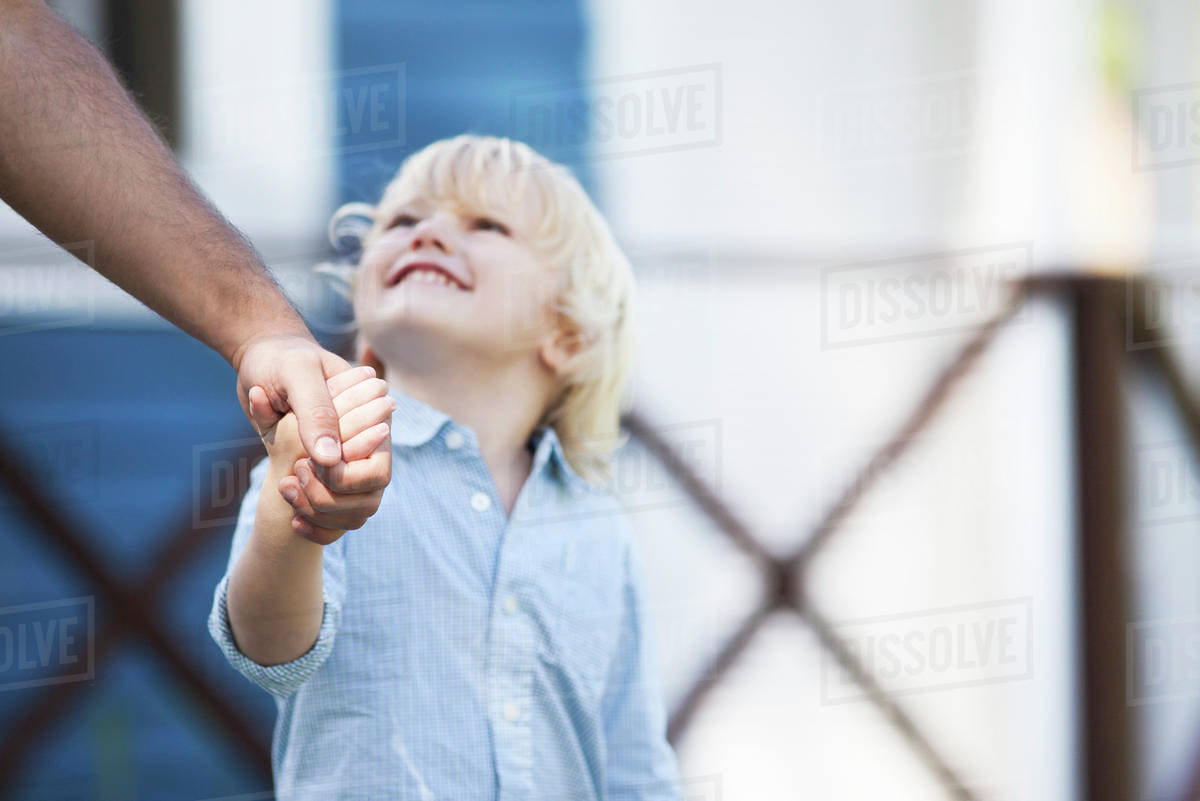 Boy holding father's hand, looking up at father - Royalty-free Stock ...
