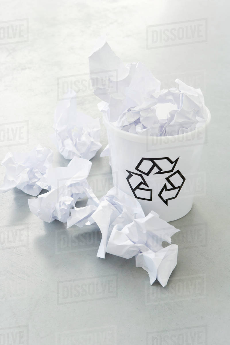 Crumpled paper overflowing recycle bin, close-up - Stock Photo - Dissolve