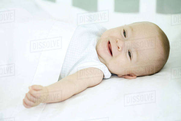 Baby lying on back, smiling, close-up - Royalty-free Stock Photo | Dissolve