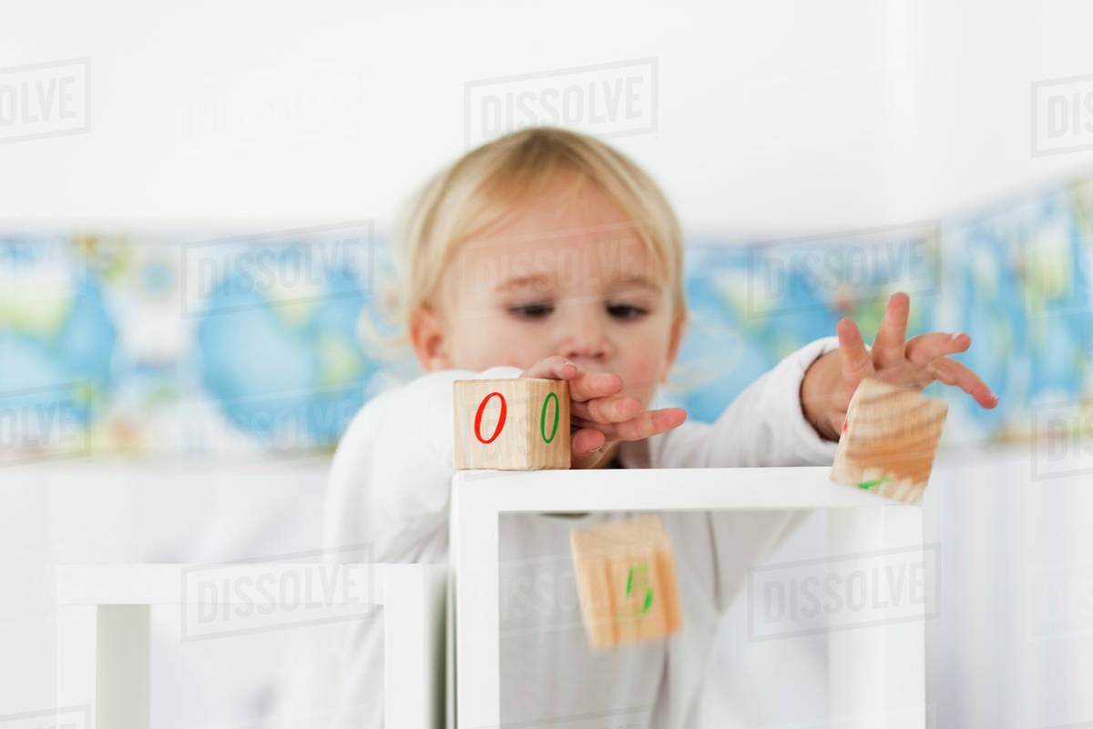 Baby pushing blocks off shelves - Royalty-free Stock Photo | Dissolve