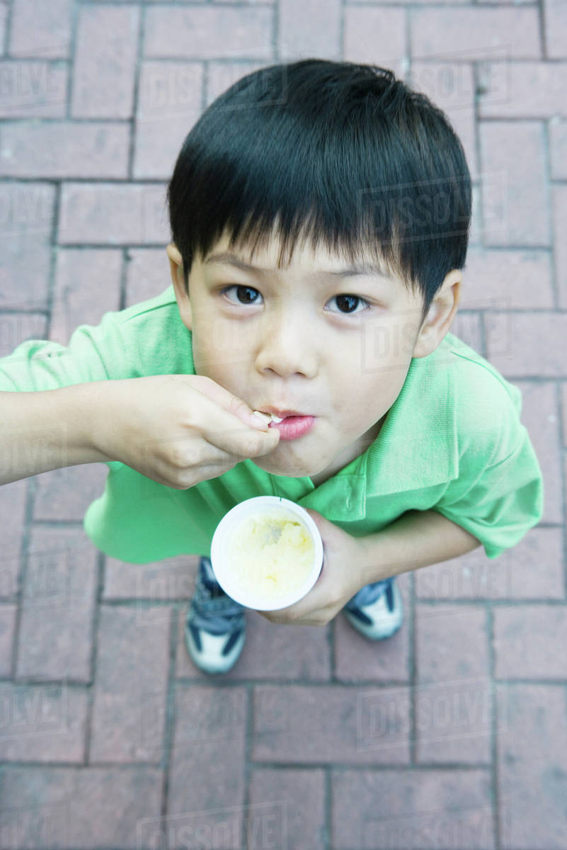 Boy eating sweet snack, smiling at camera - Royalty-free Stock Photo ...