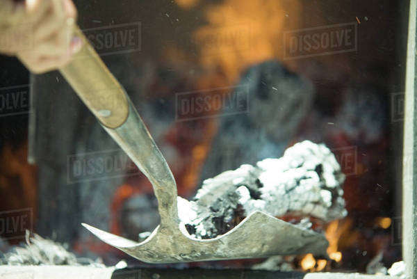 Person shoveling ashes in wood oven - Royalty-free Stock Photo | Dissolve