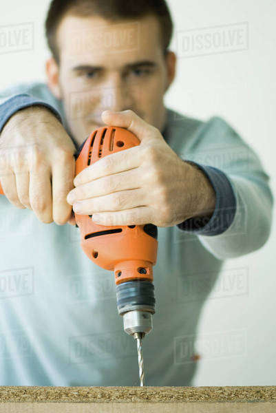 Man using drill, focus on drill in foreground - Royalty-free Stock ...
