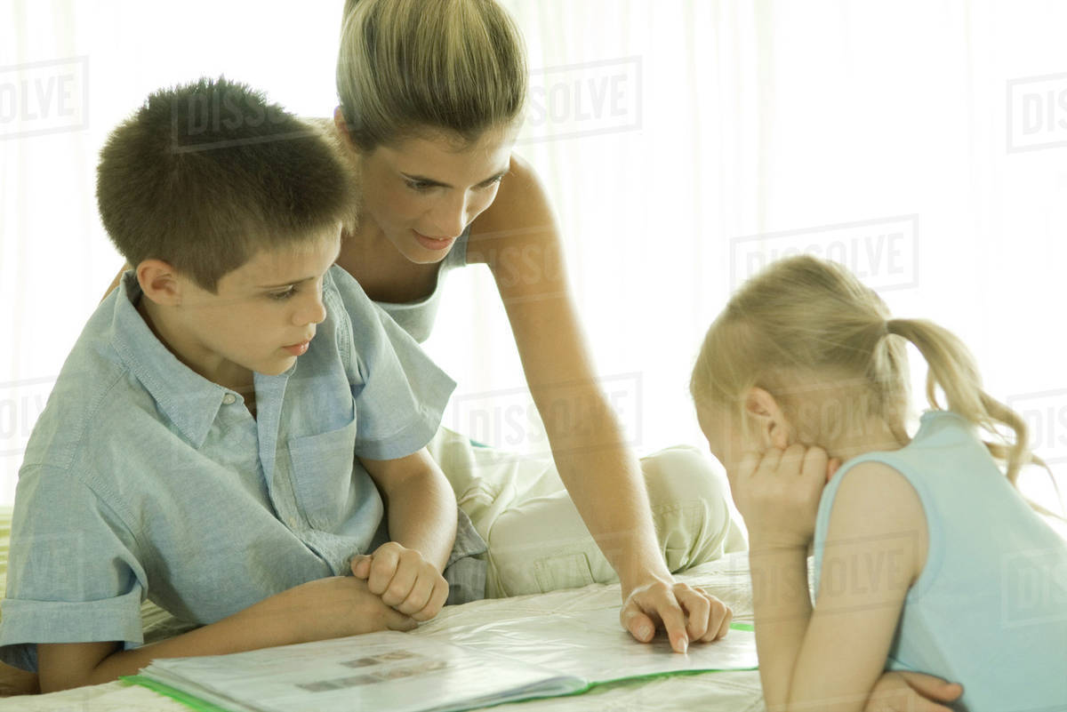 Mother helping children with homework - Stock Photo - Dissolve
