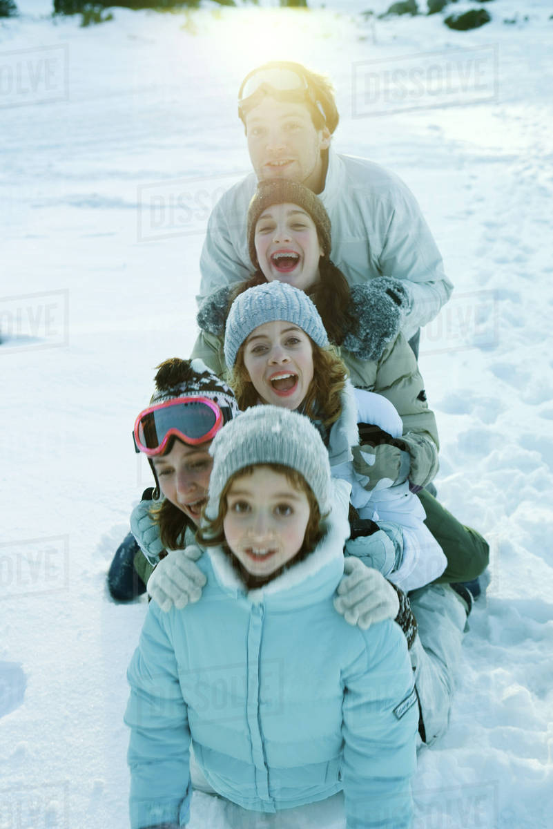 Group kneeling in snow, lined up one behind the other, smiling and ...