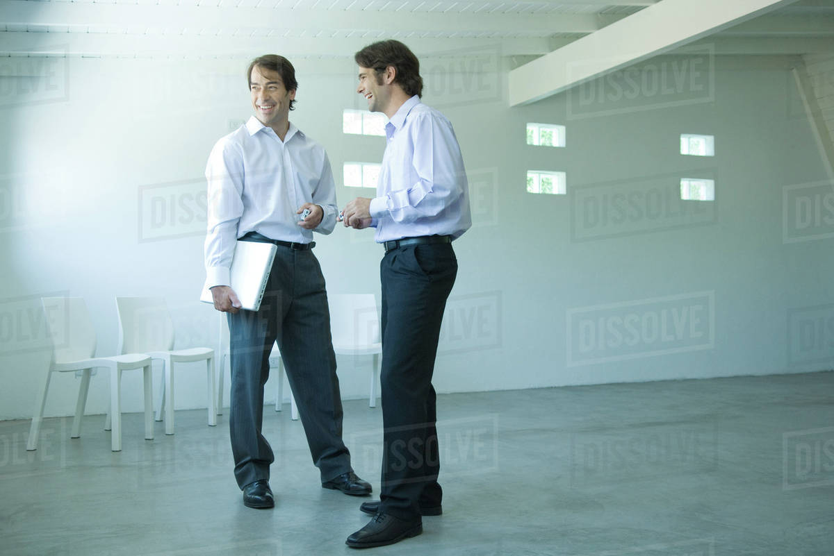 Two businessmen laughing, full length view - Stock Photo - Dissolve