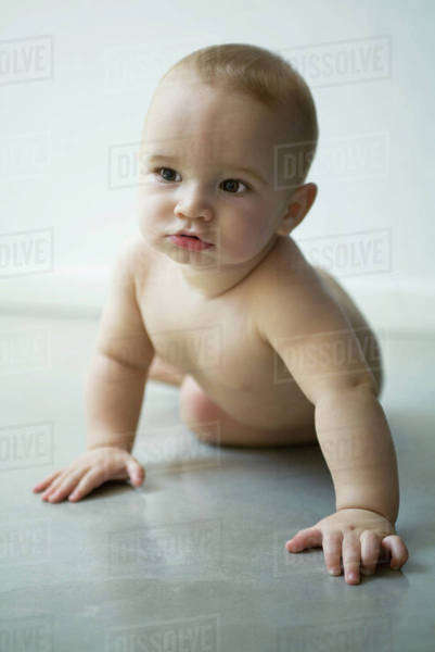 Baby on floor, pushing self up with arms, looking away, portrait ...