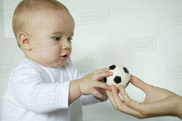 Baby taking ball from mother's hand, close-up - Royalty-free Stock ...
