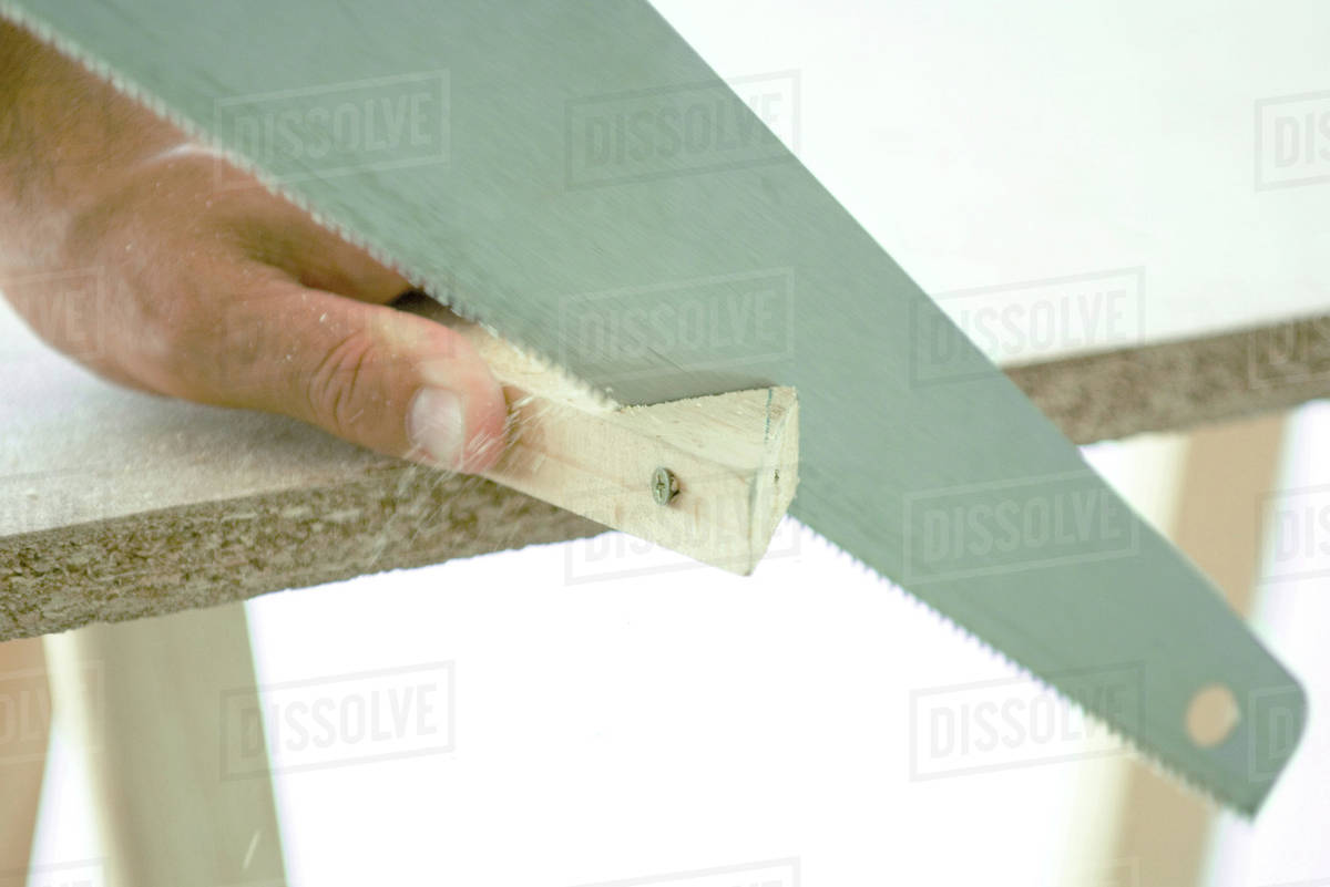 Man cutting corner off piece of wood, close-up - Stock Photo - Dissolve