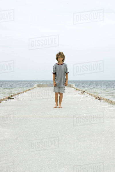 Boy standing on pier, looking at camera - Royalty-free Stock Photo ...