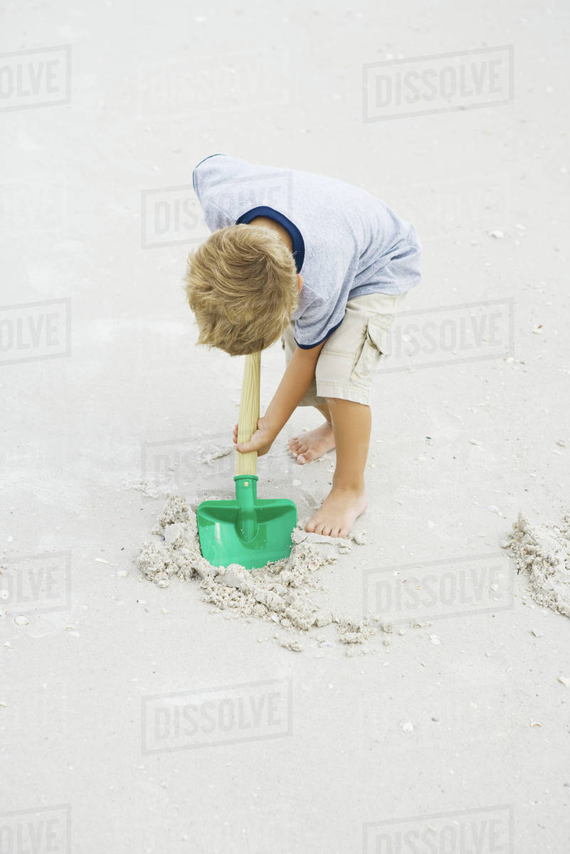 Young boy digging in sand with shovel, full length - Royalty-free Stock ...