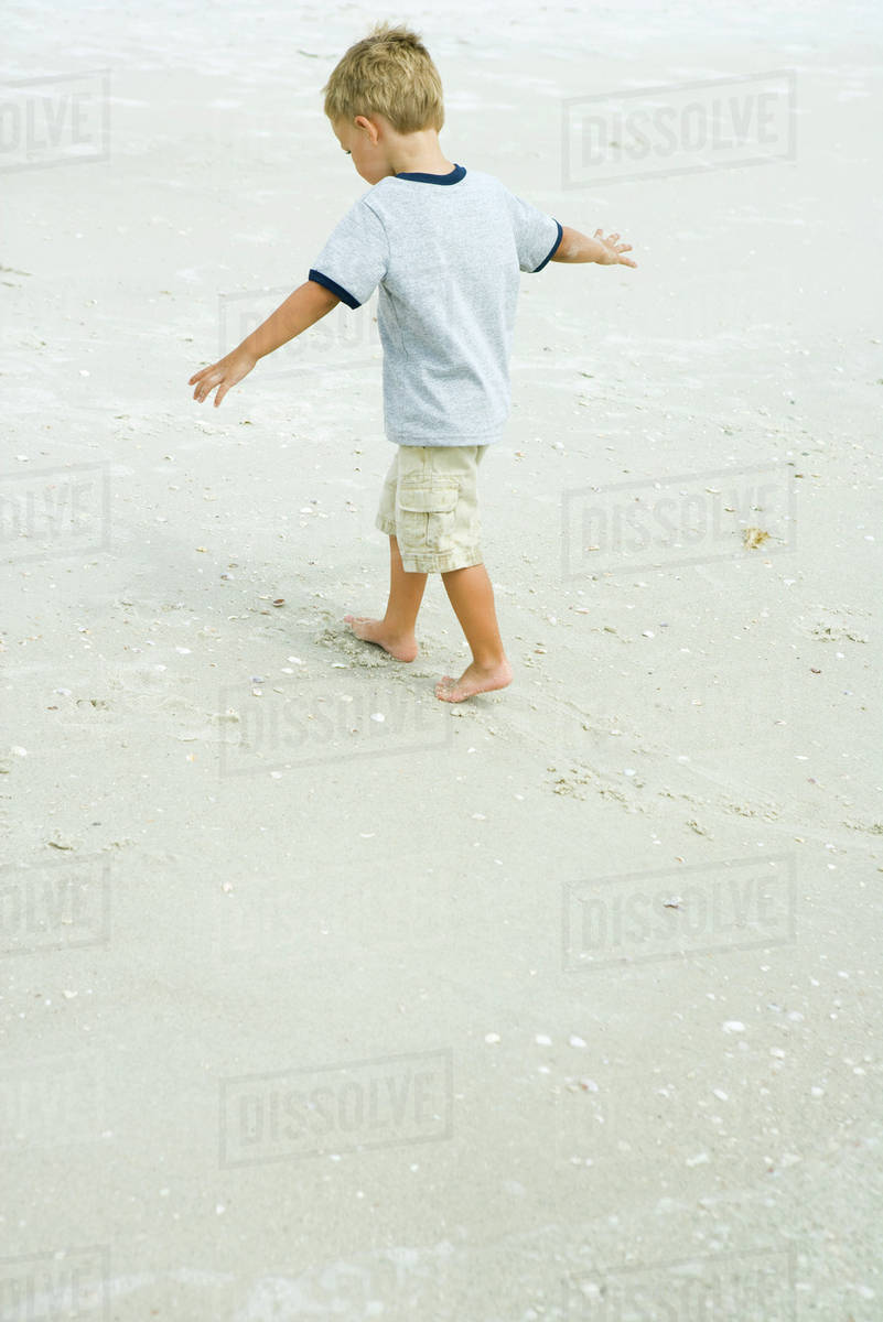 Little boy walking on beach with arms out, full length - Stock Photo ...