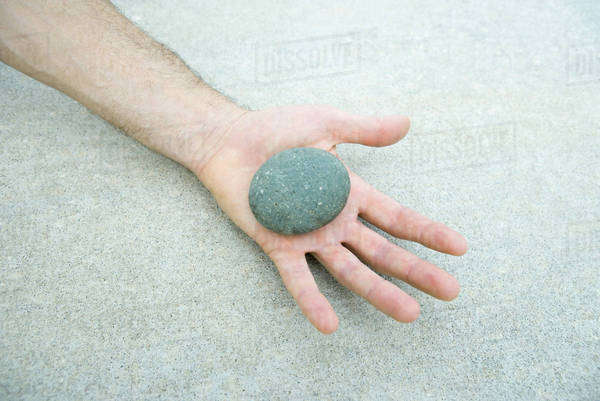 Man holding pebble in hand, cropped view - Royalty-free Stock Photo ...