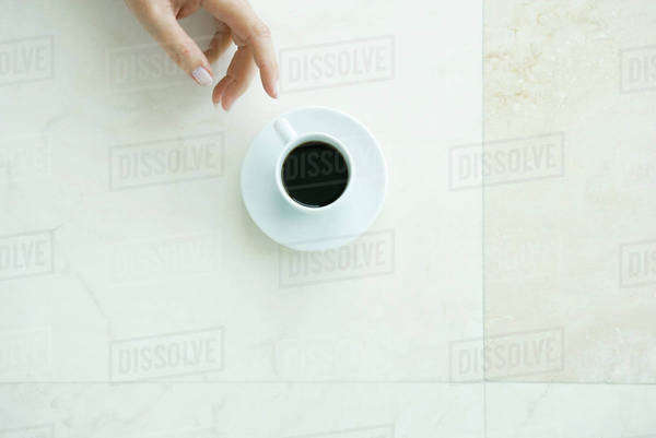 Hand reaching for coffee cup, viewed from directly above - Stock Photo ...