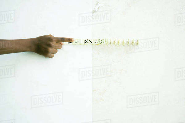 Child knocking over line of dominoes, cropped view of hand - Stock ...