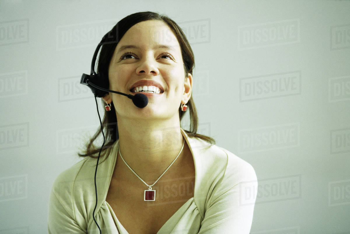 Woman wearing headset, head back, smiling, looking up - Royalty-free ...