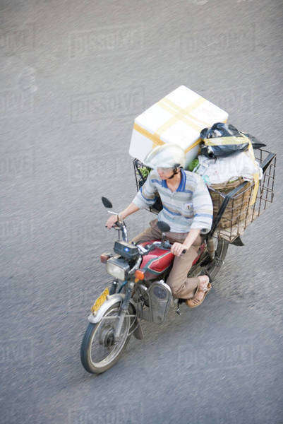 Man riding moped loaded with boxes, high angle view - Stock Photo ...