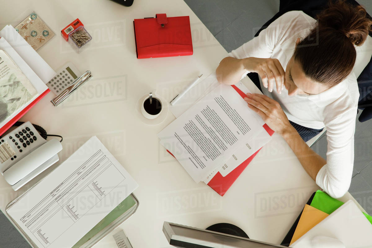 Businesswoman at desk busy with paperwork, overhead view - Royalty-free ...